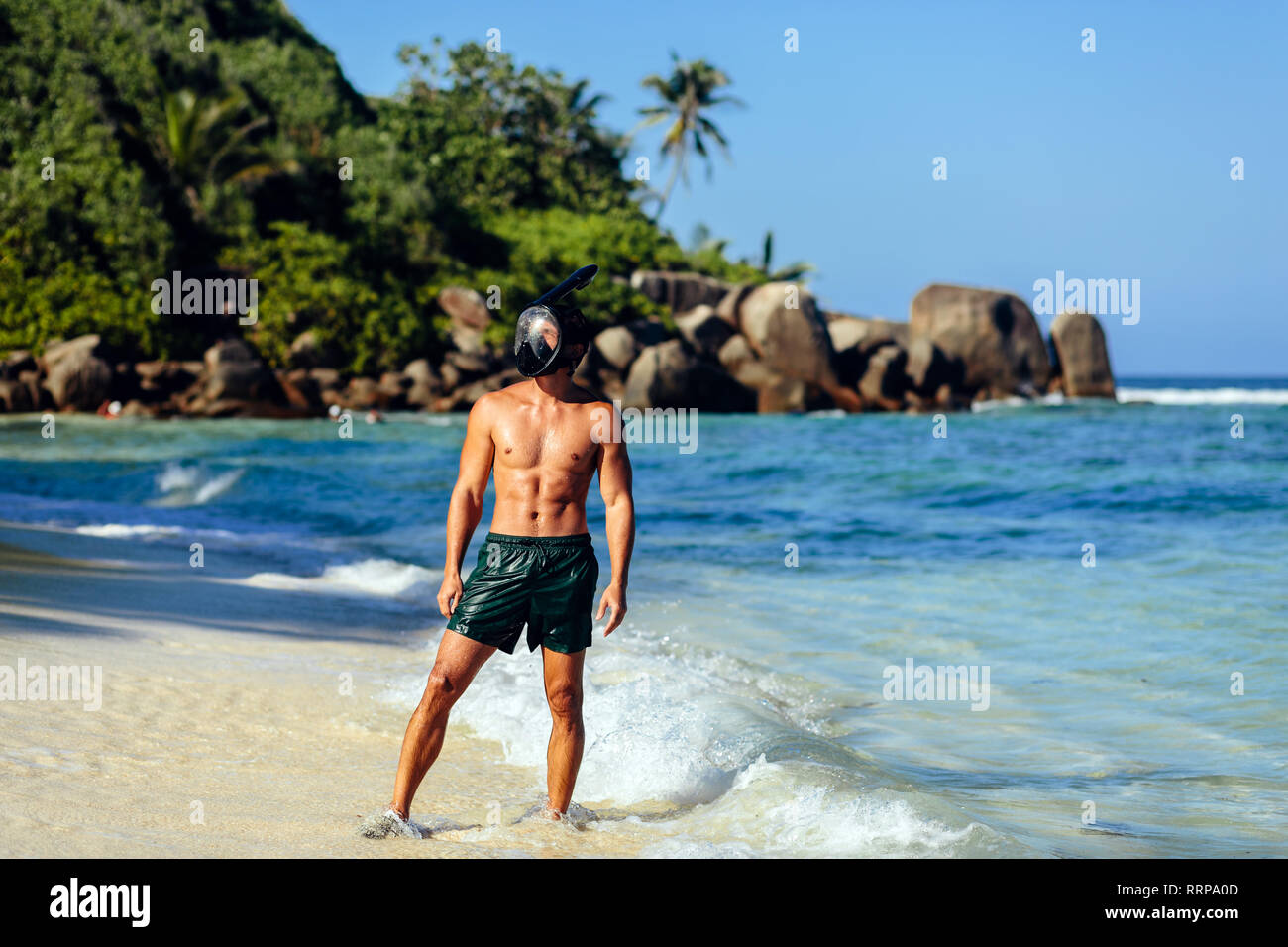 Man Relax On Beach With Snorkeling Mask Male Travel With Full Face Ninja Mask Seychelles Stock