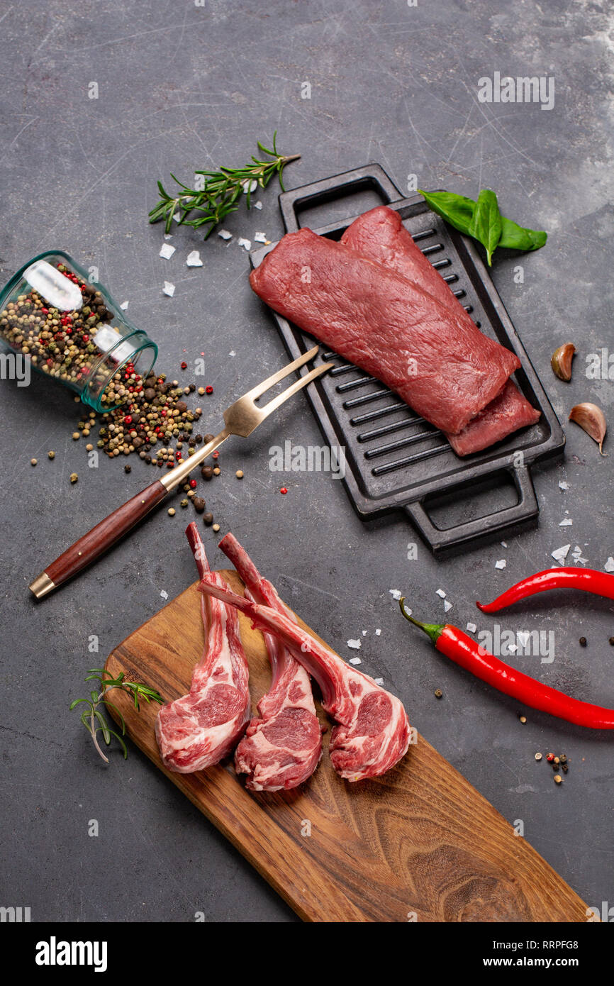 Meat Raw Fresh Mutton on the bone Spices Chesno and Rosemary on a black ...