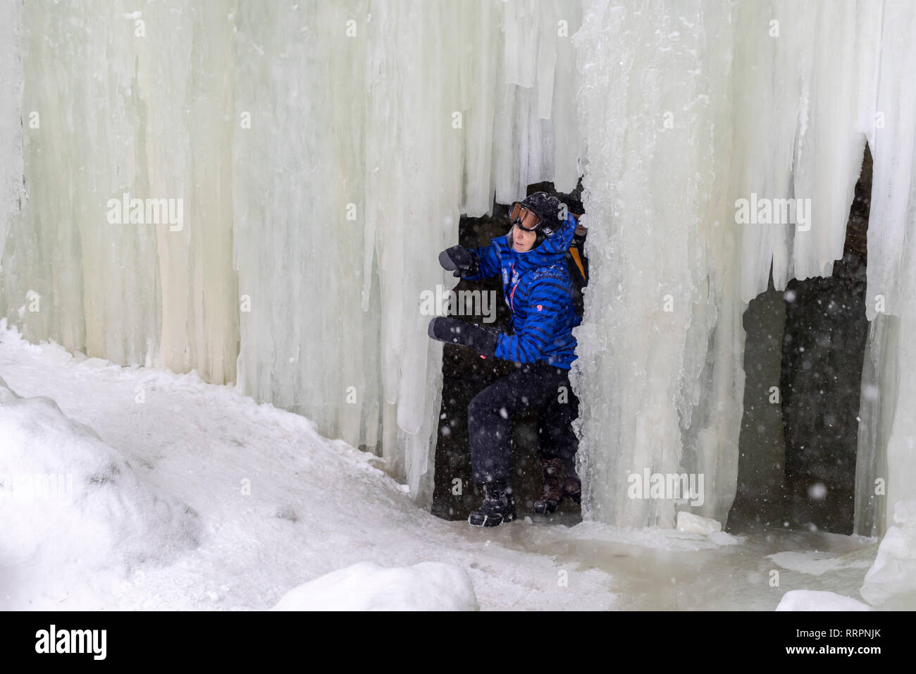 Eben Junction, Michigan - A woman climbs out of the Eben Ice Caves ...