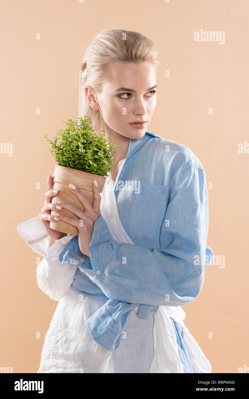 woman holding pot with plant and standing in eco clothing isolated on ...
