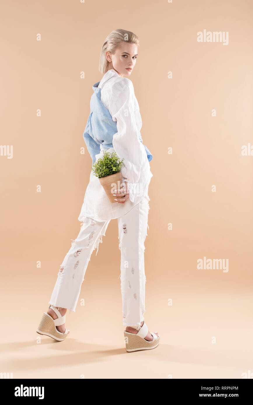 beautiful girl holding pot with plant and standing in eco clothing ...