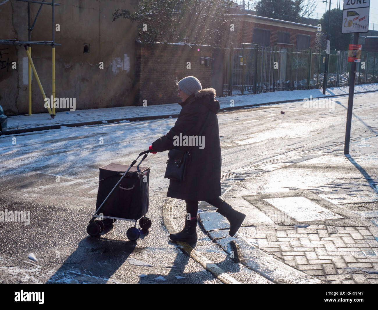 A woman pushes a shopping trolley along the street in north London ...