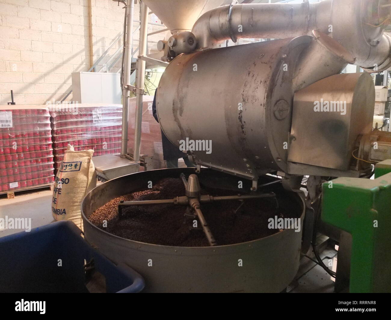 Coffee beans being ground and roasted in a giant vat at the premises of ...