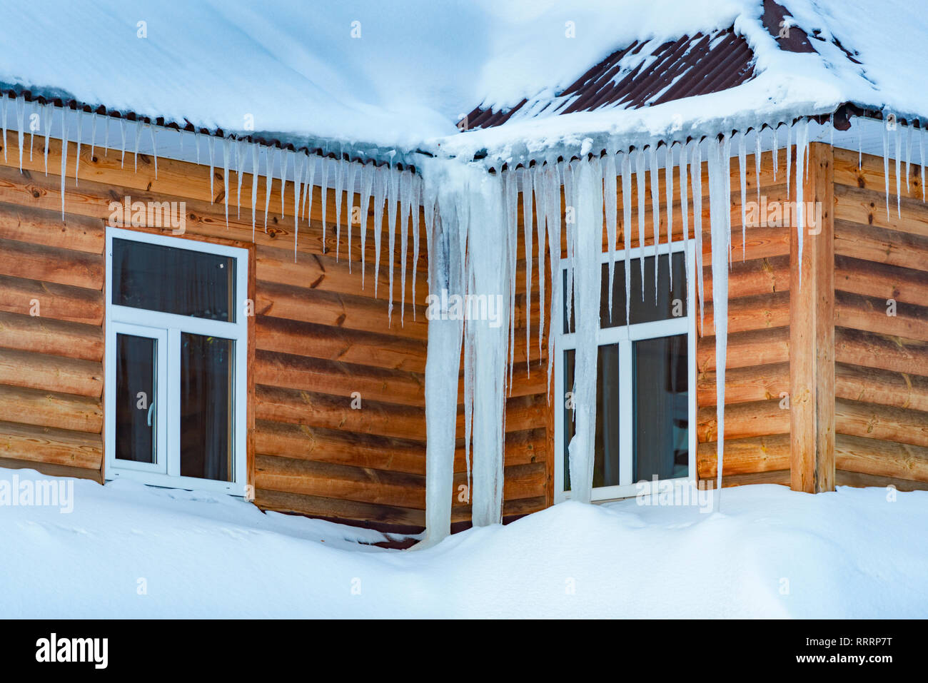 Wooden house covered with snow and icicles. Winter in Russia Stock ...