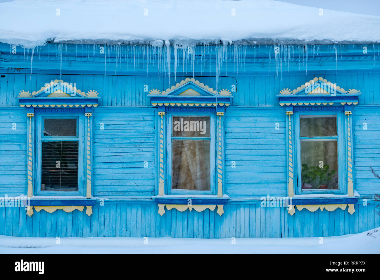 Wooden house covered with snow and icicles. Winter in Russia Stock ...