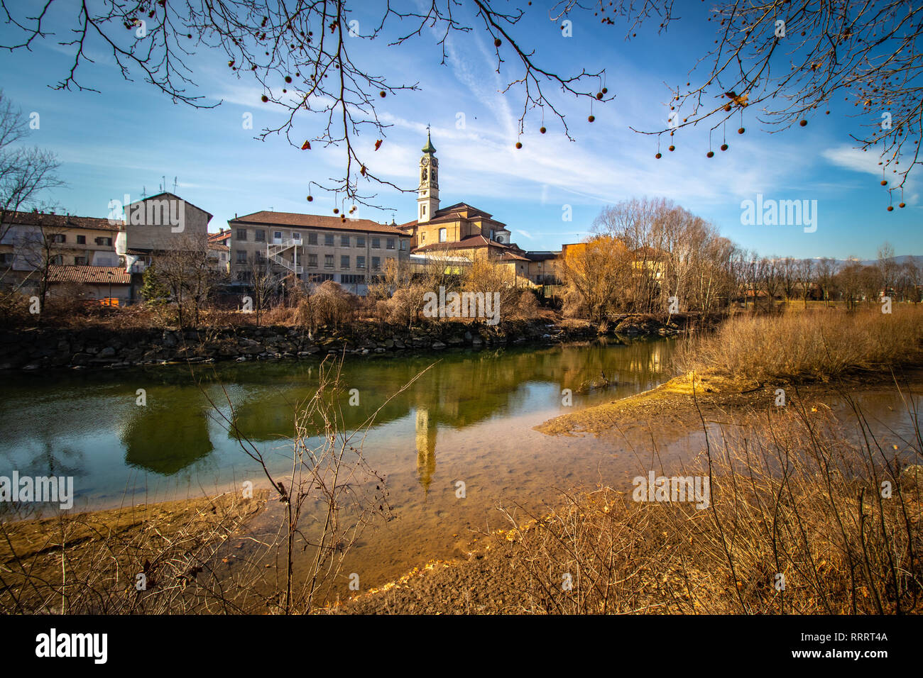 Beautiful river, old church, and buildings surrounded by golden grass ...