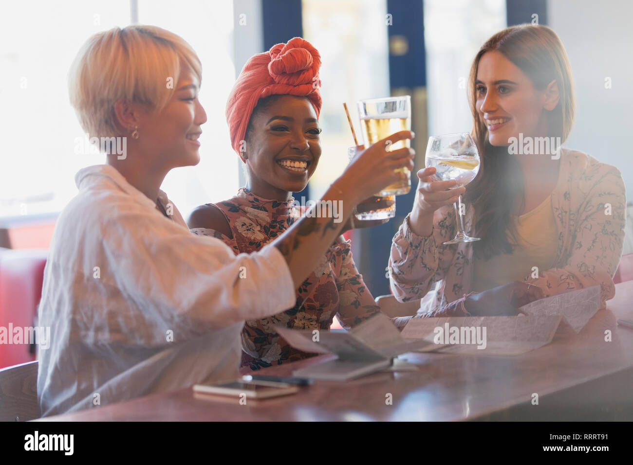 Happy Carefree Young Women Friends Toasting Cocktail Glasses In Bar