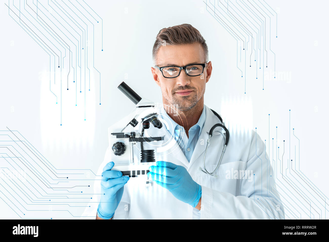 handsome scientist in glasses holding microscope and looking at camera ...