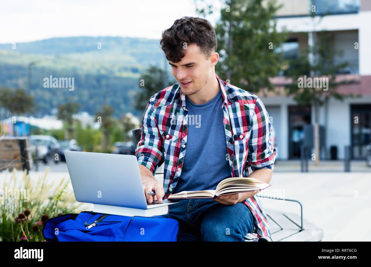 Male student learning at computer outdoor on campus of university Stock ...