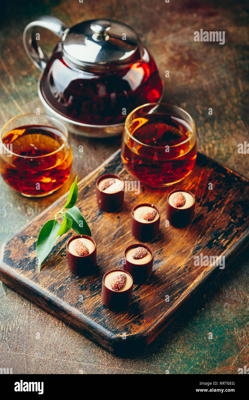 Glass transparent teapot and two glass cups with black tea with ...