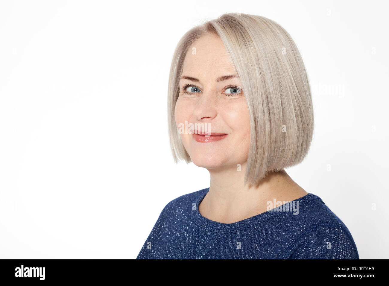 Attractive middle aged woman with folded arms emotionally posing in studio on white background ...