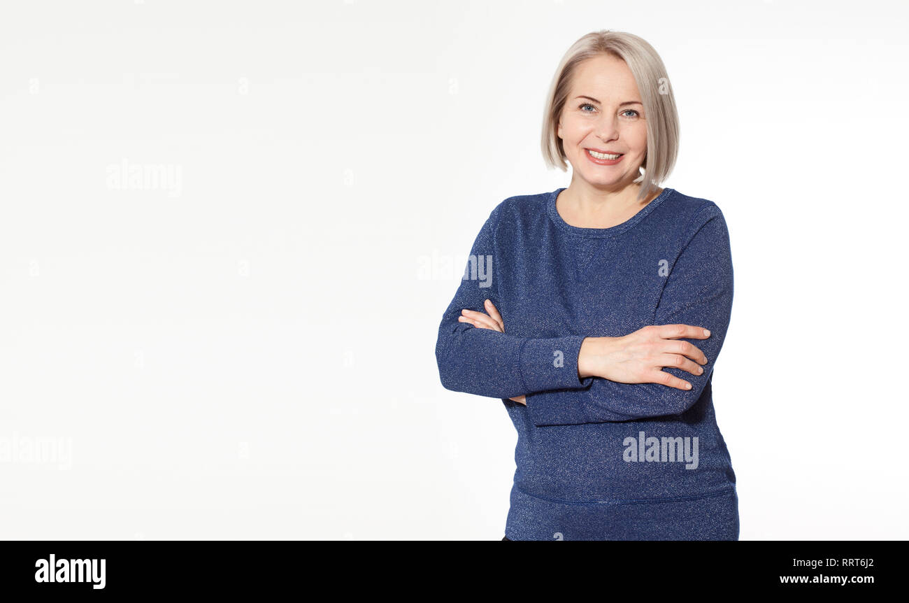 Attractive middle aged woman with folded arms emotionally posing in studio on white background ...