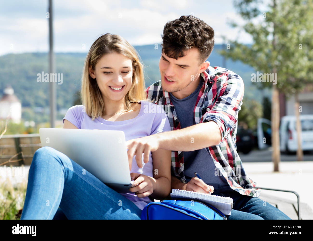 Beautiful german student couple with computer outdoor on campus of ...