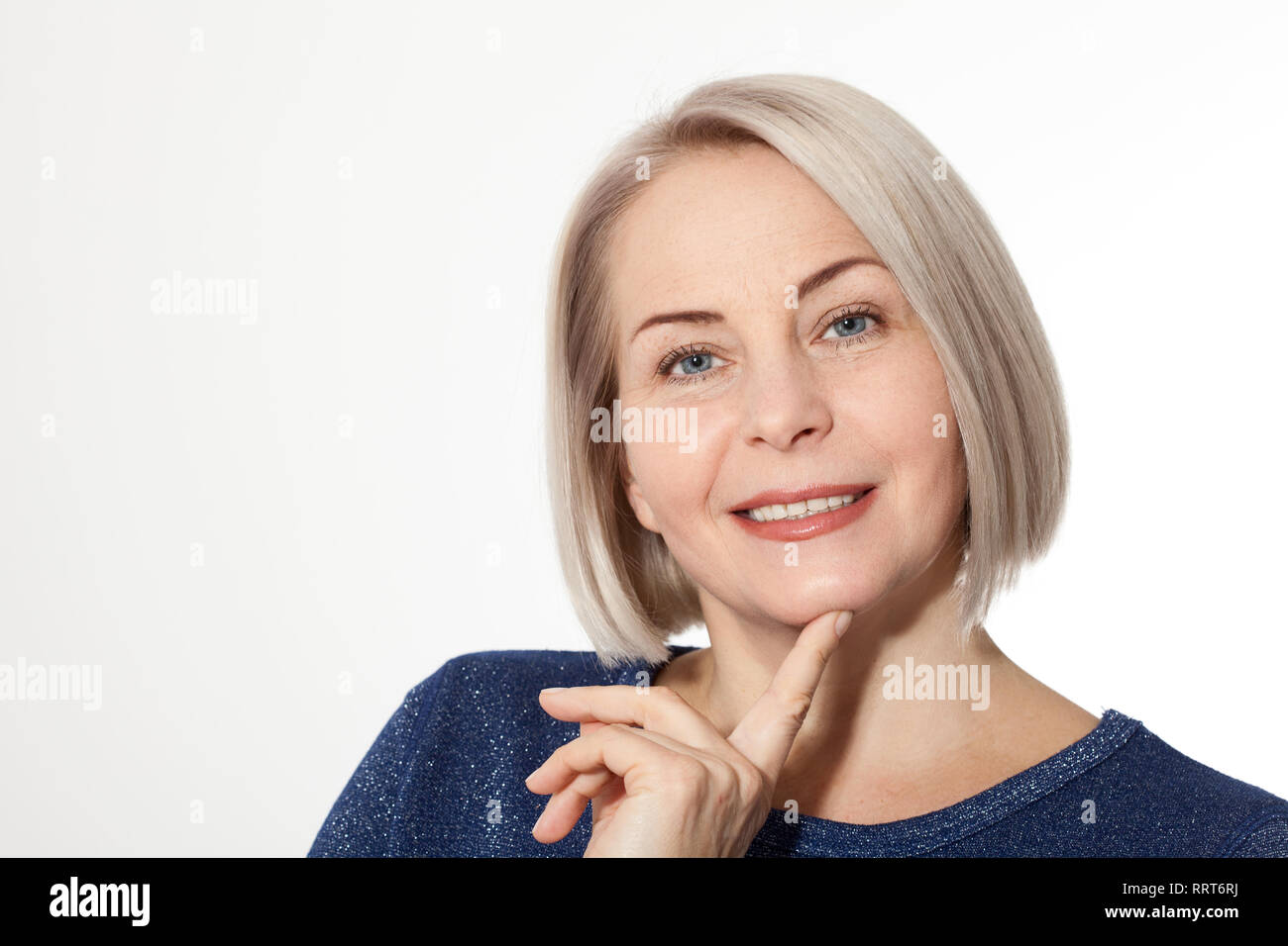 Attractive middle aged woman with folded arms emotionally posing in studio on white background ...
