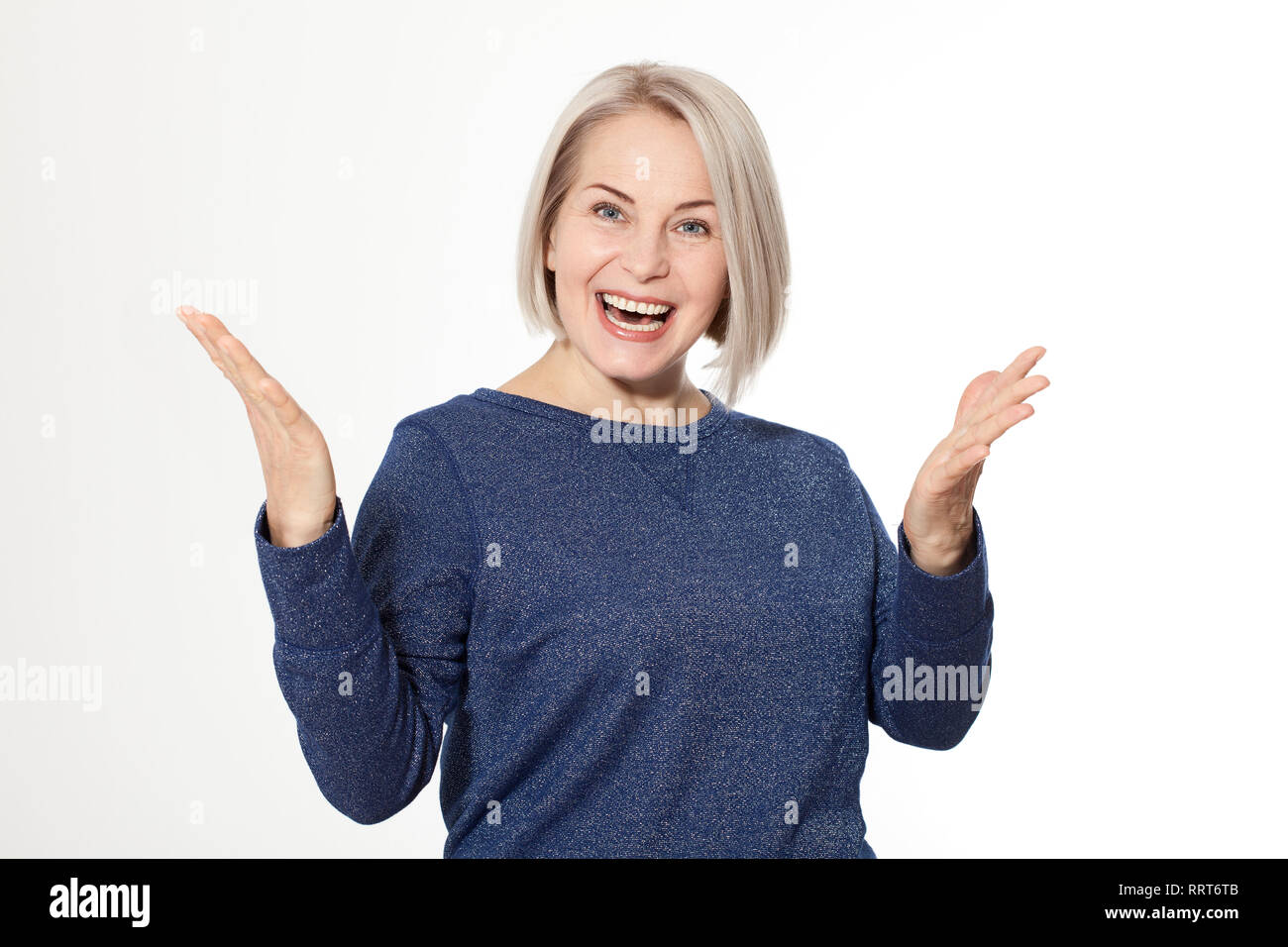 Attractive middle aged woman with folded arms emotionally posing in studio on white background ...