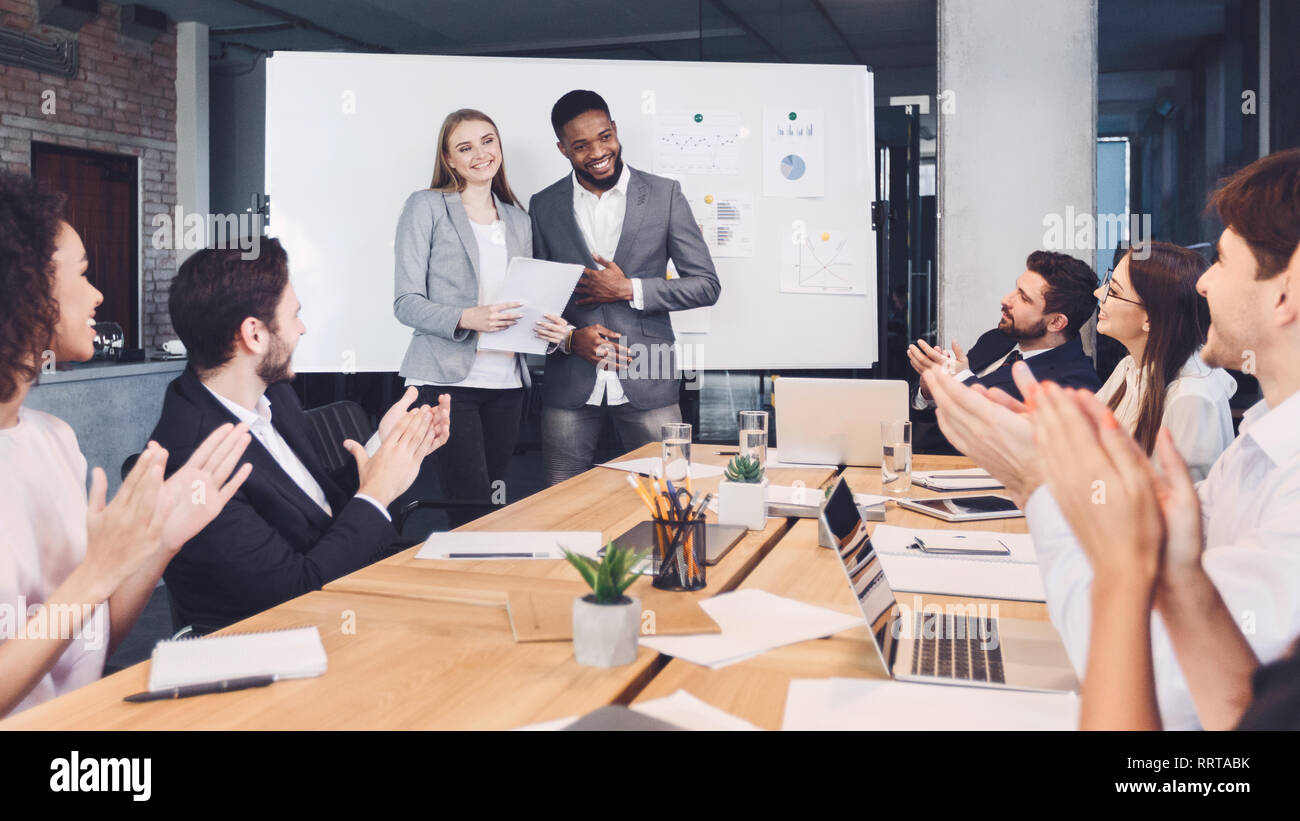 Boss welcoming new employee and representing to colleagues Stock Photo ...