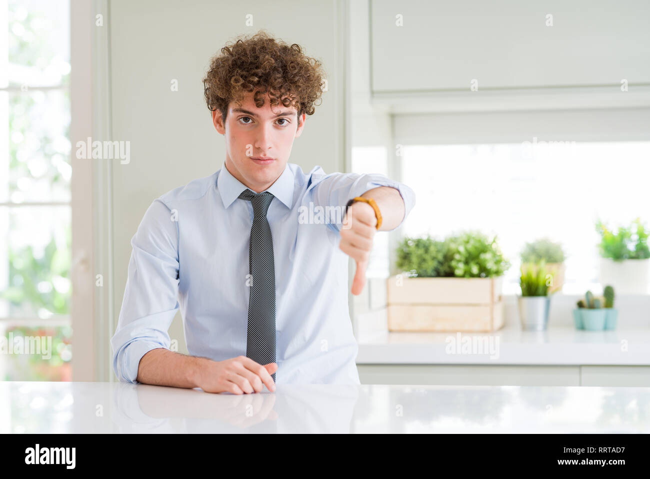 Young business man wearing a tie looking unhappy and angry showing ...