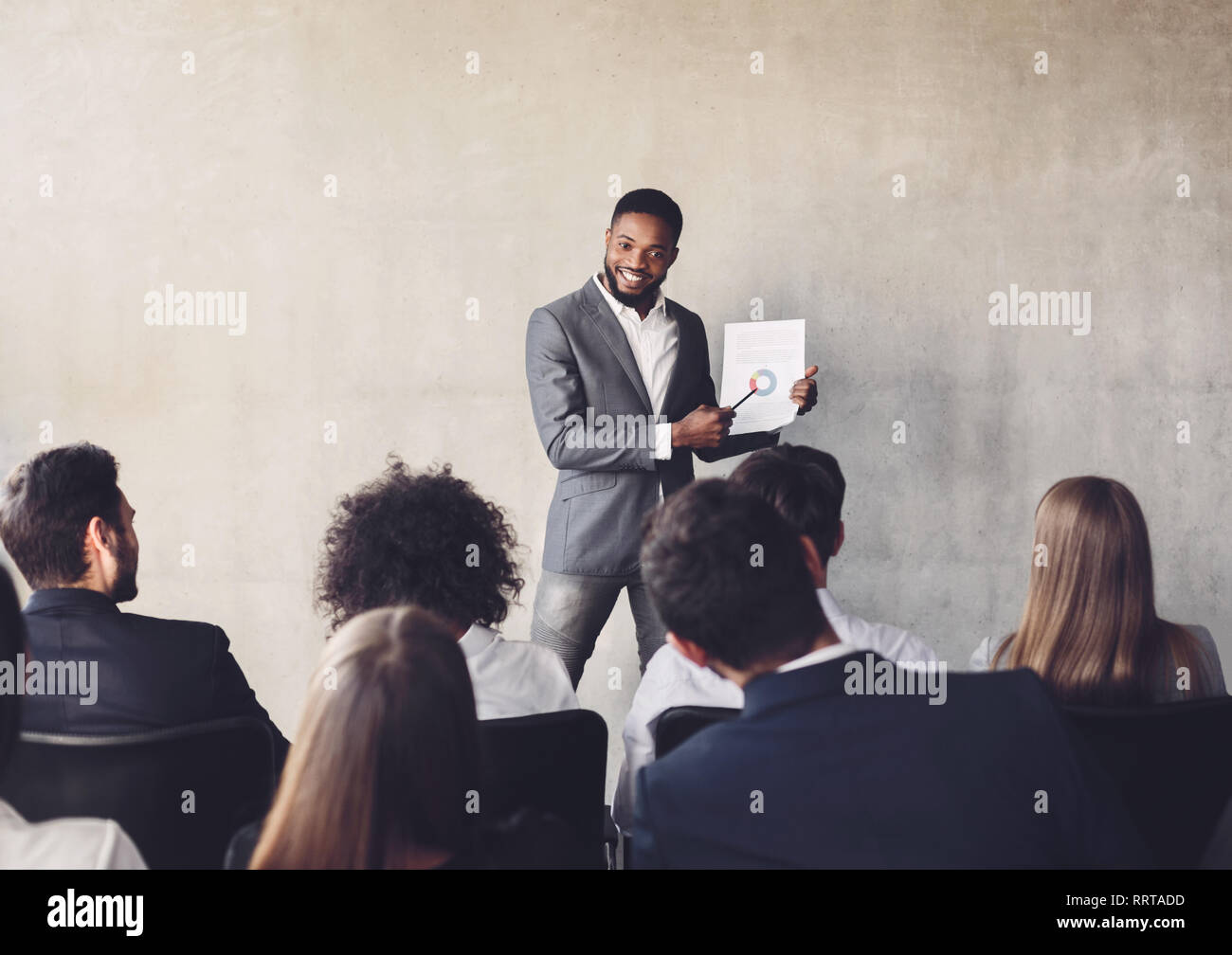 Successful businessman presenting diagrams to colleagues on training ...