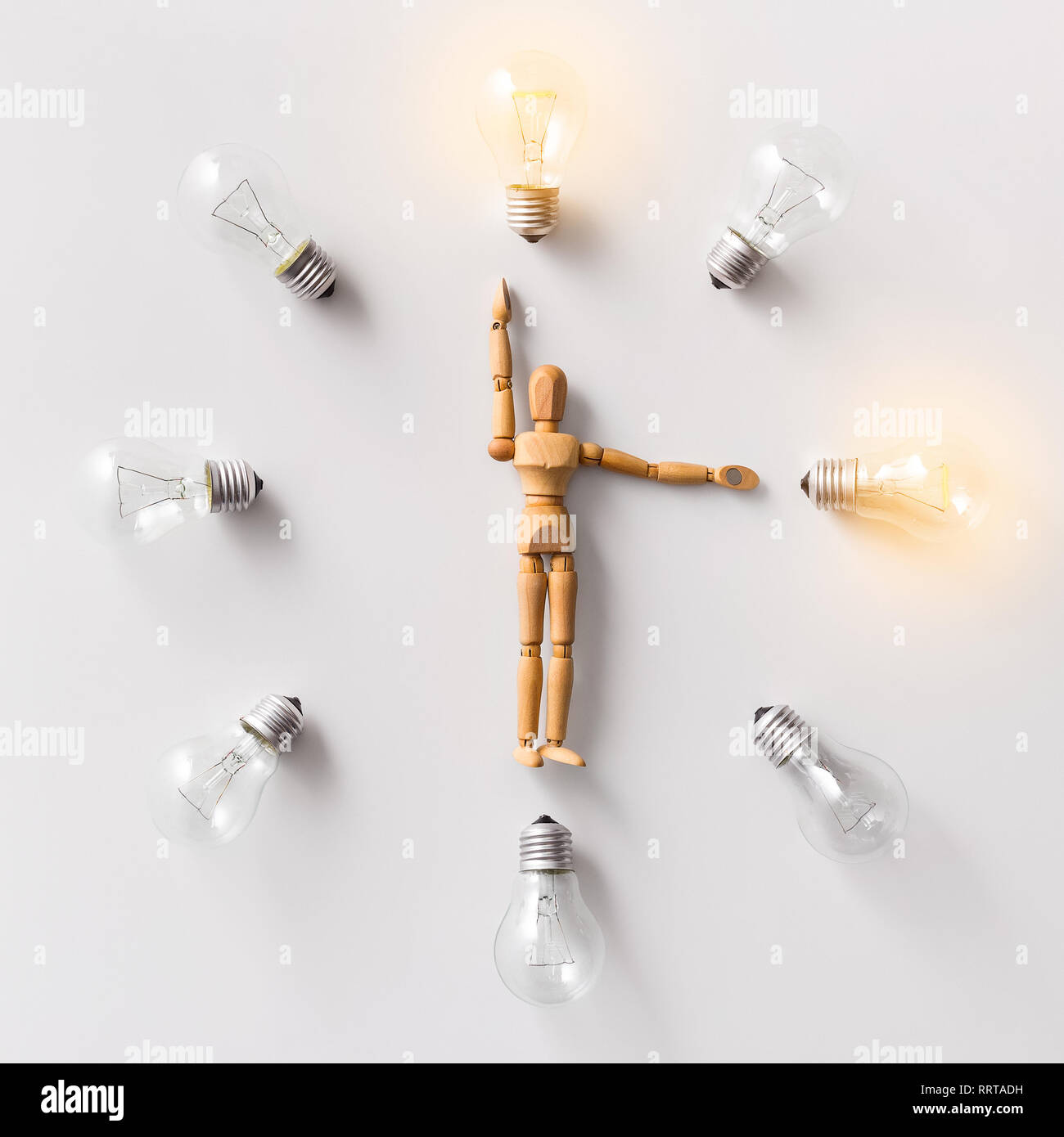 Wooden mannequin carrying glowing light bulbs on white Stock Photo - Alamy
