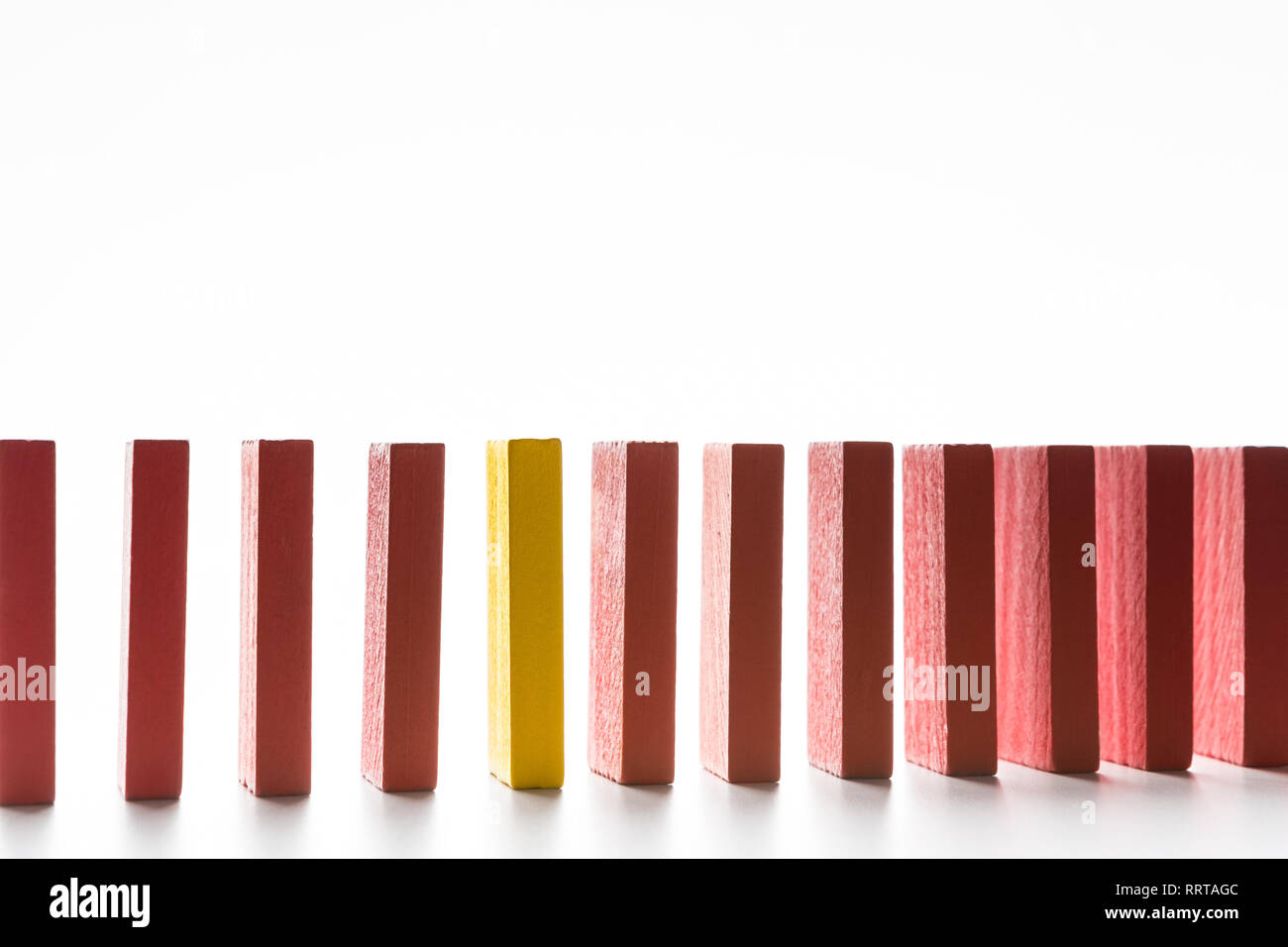 Yellow wooden block between row of red ones on white Stock Photo - Alamy