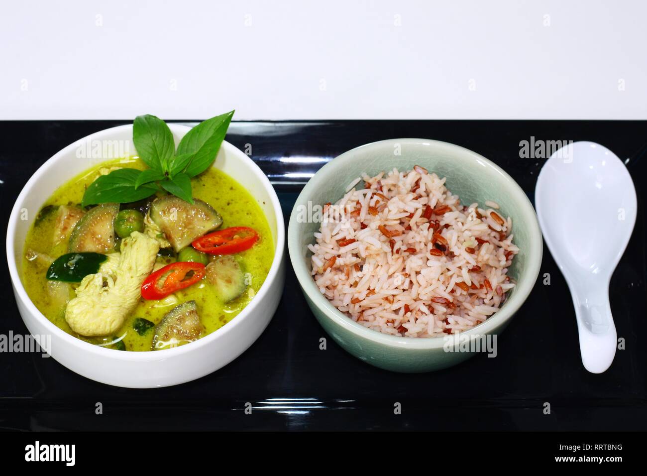 Thai Green curry chicken served with brown rice Stock Photo - Alamy