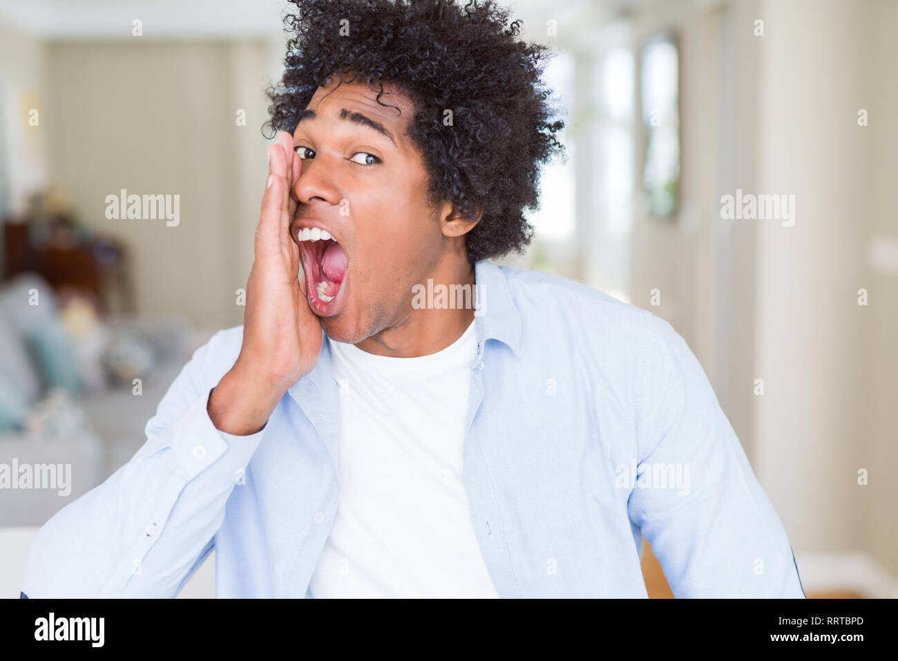 African American man at home shouting and screaming loud to side with ...