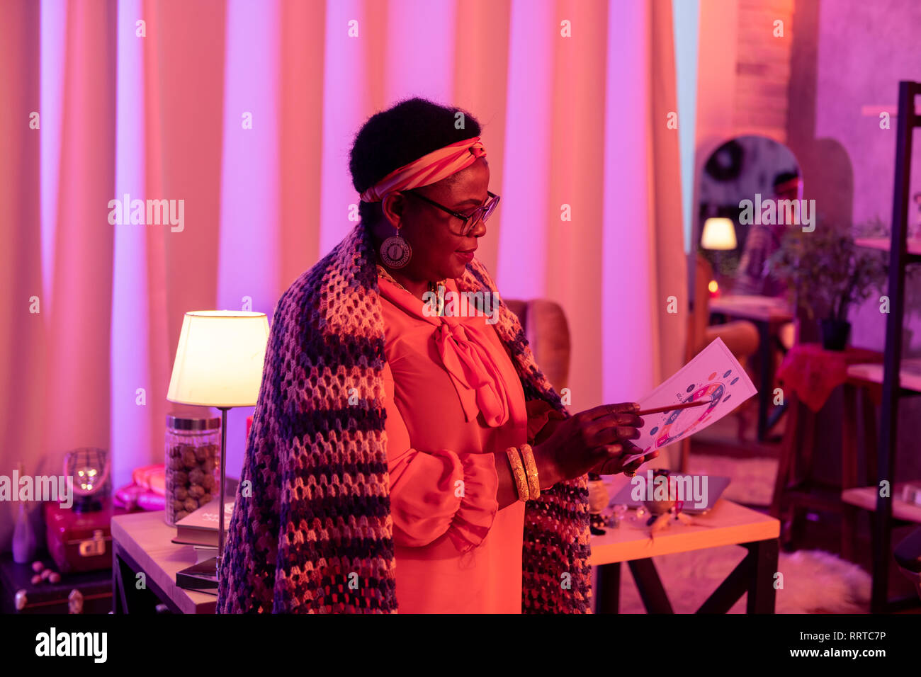 African american plump fortune-teller in a bright woolen shawl working ...