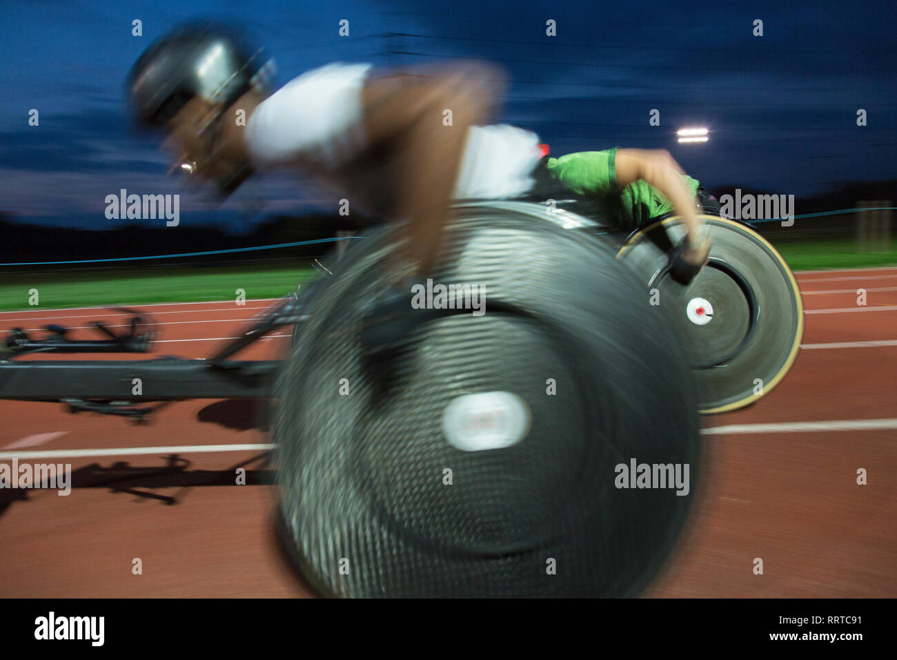 Paraplegic athletes speeding along sports track in wheelchair race at ...