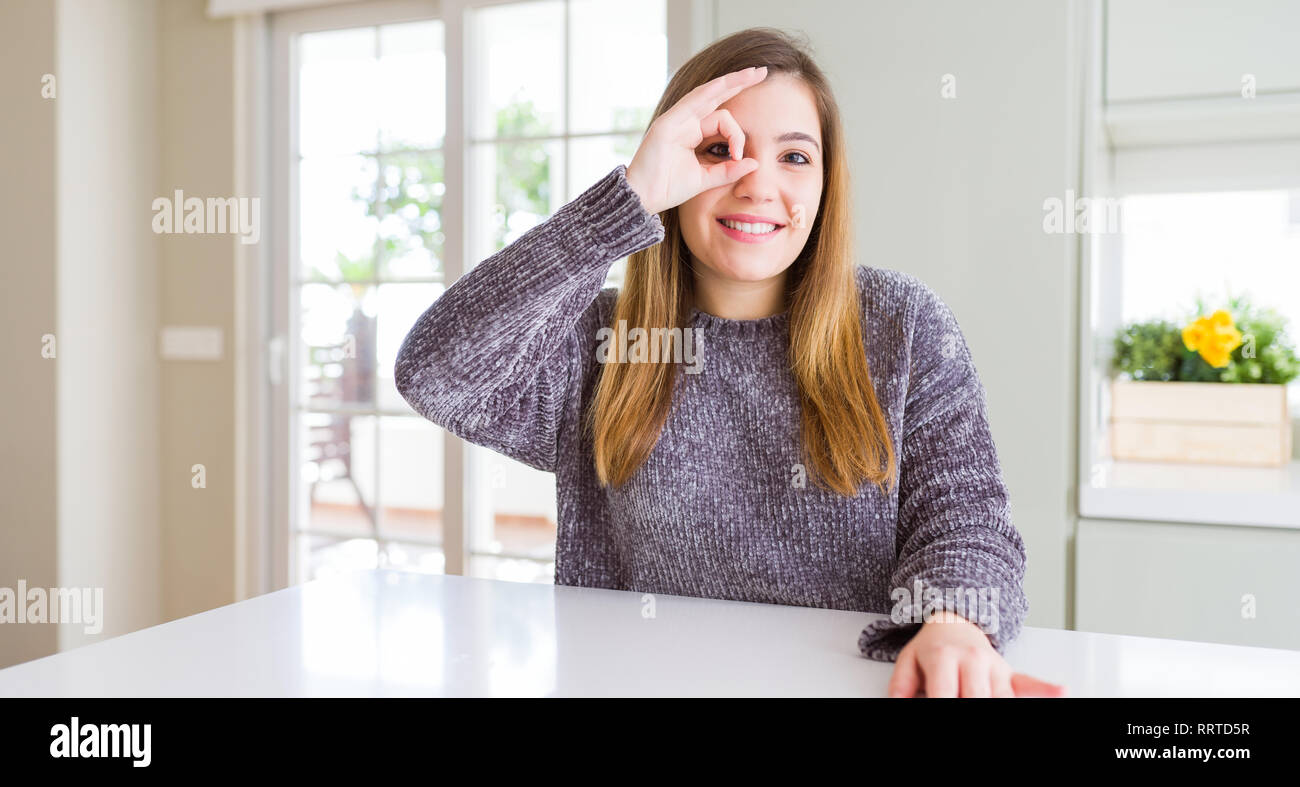 Beautiful young woman at home doing ok gesture with hand smiling, eye ...