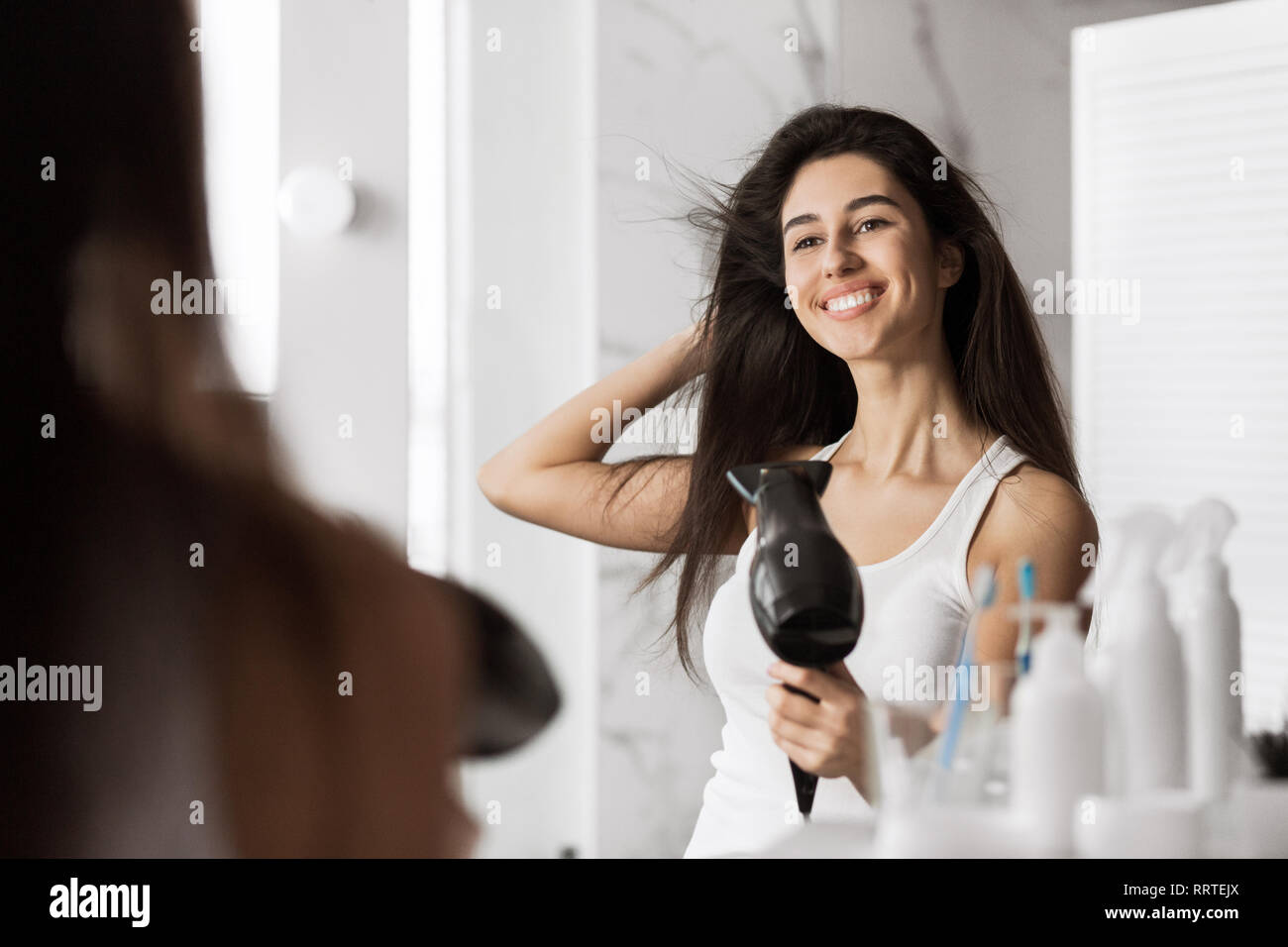 Beautiful girl drying her hair Stock Photo - Alamy
