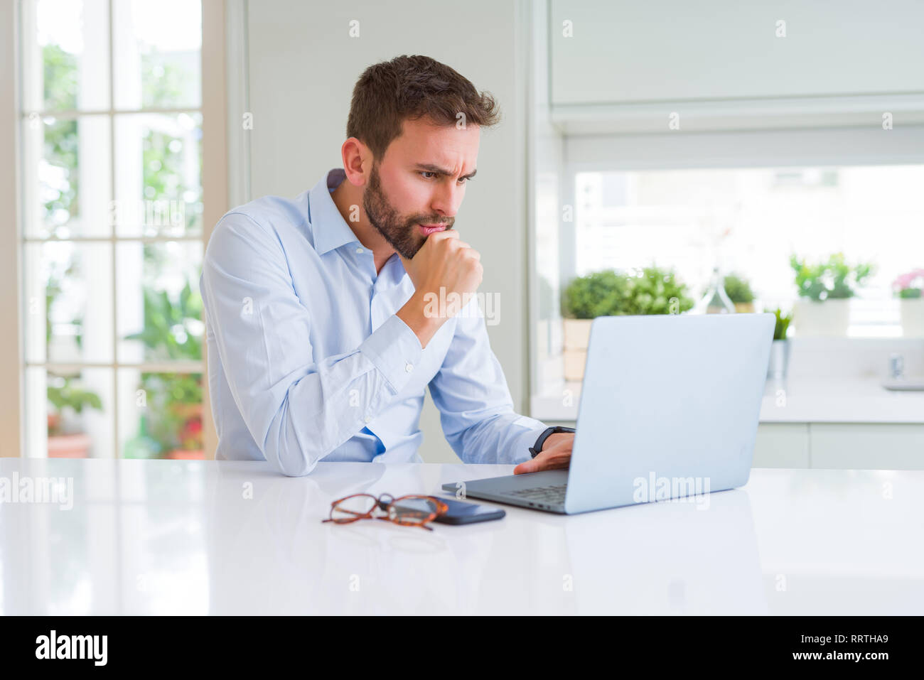 Handsome business man working using computer laptop serious face ...