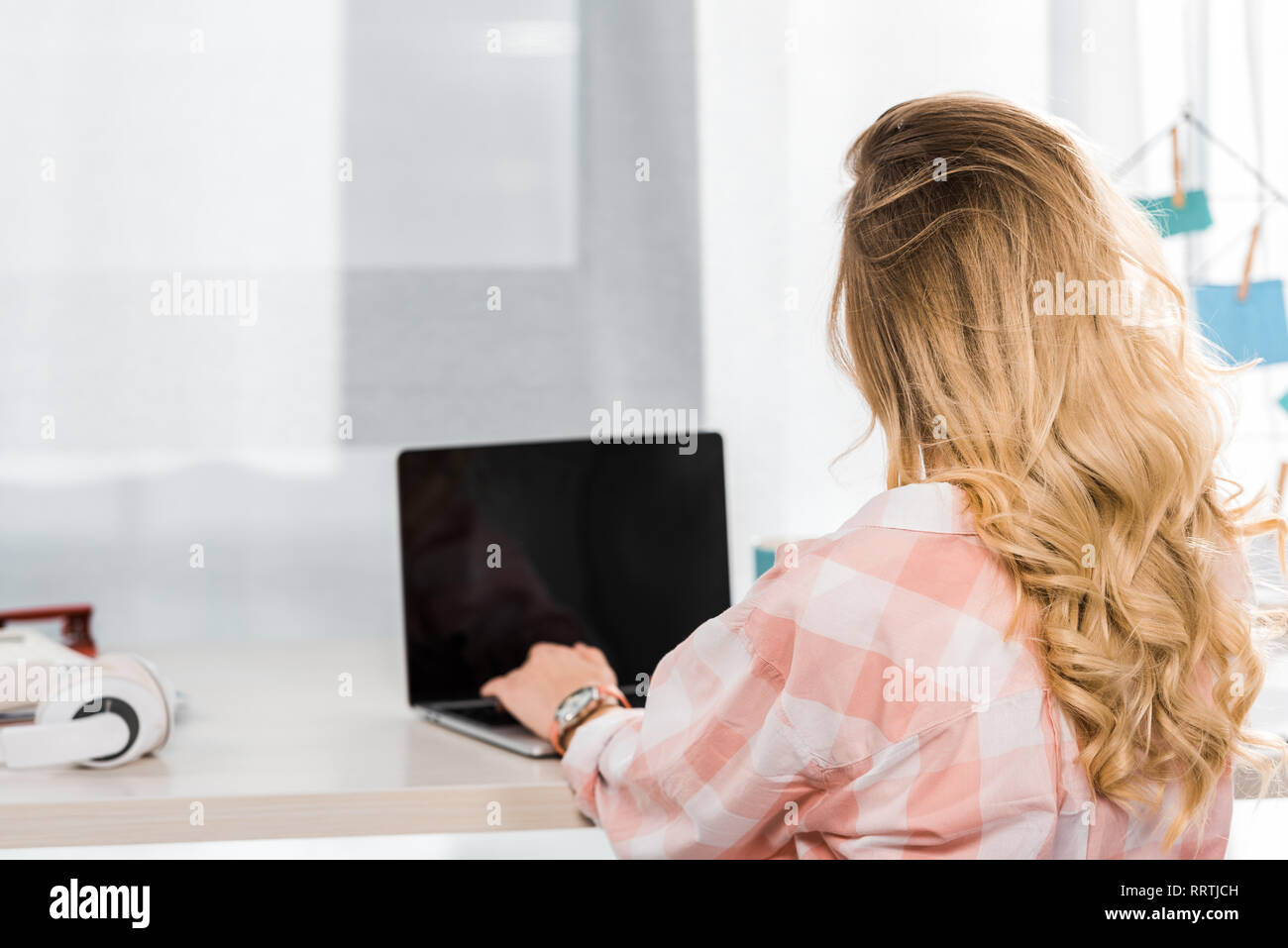 Back view of blonde young woman using laptop with blank screen Stock ...