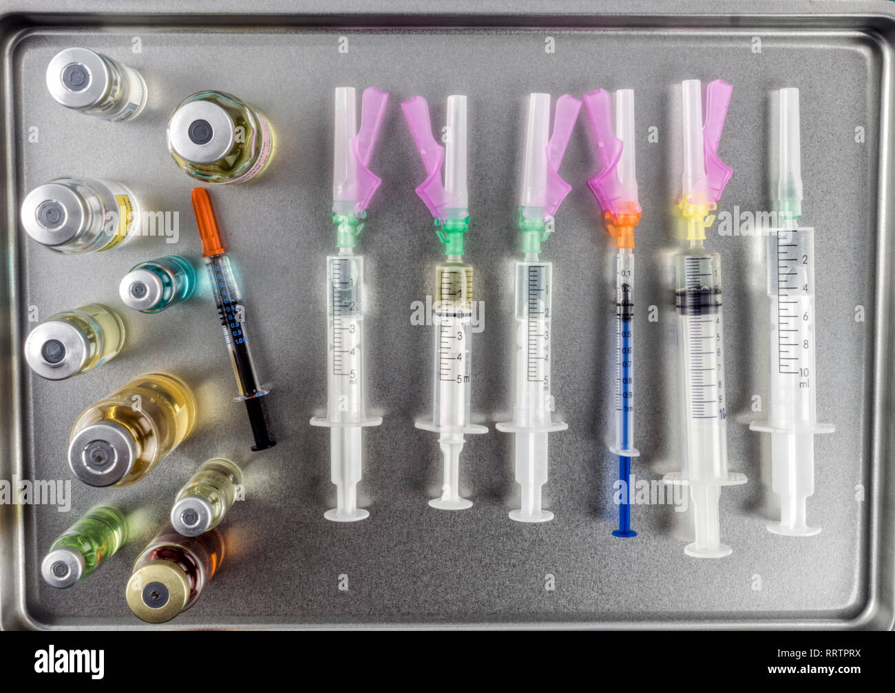 Syringes loaded with medication next to medicine vials prepared in ...
