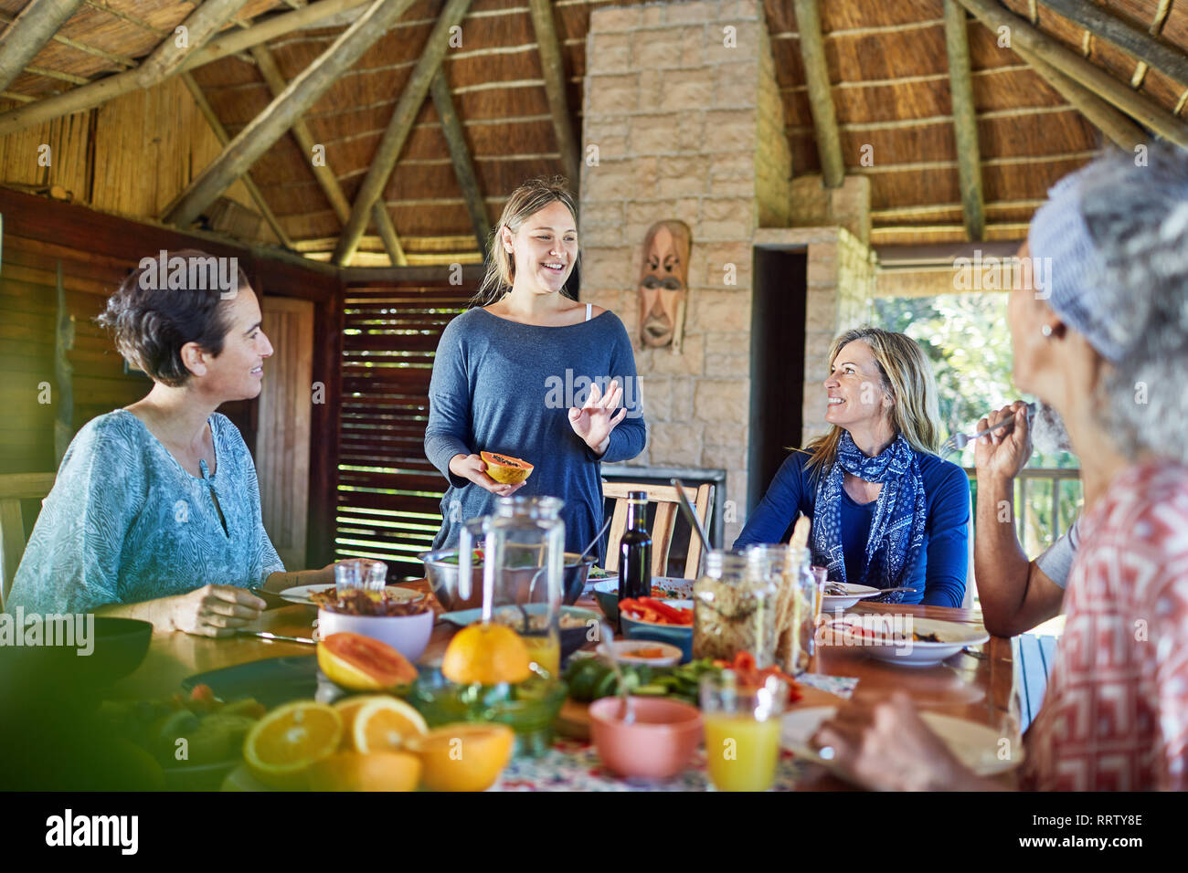 Friends enjoying healthy breakfast in hut during yoga retreat Stock ...