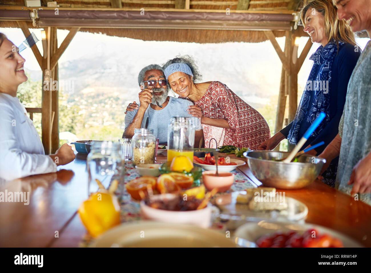 Couple hugging, enjoying healthy breakfast in hut during yoga retreat ...
