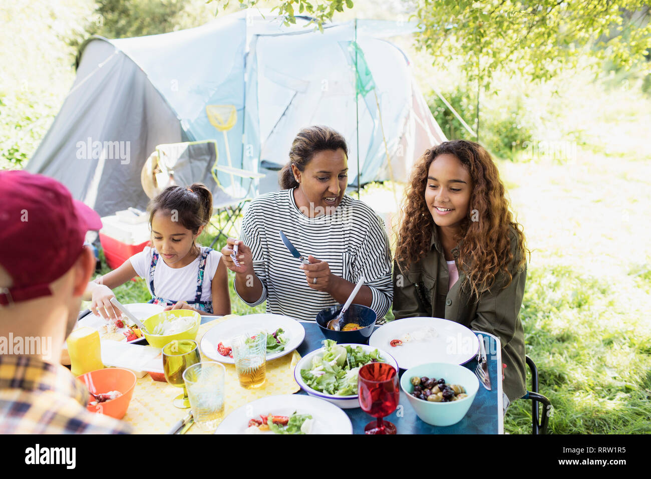 Family enjoying lunch at campsite table Stock Photo - Alamy