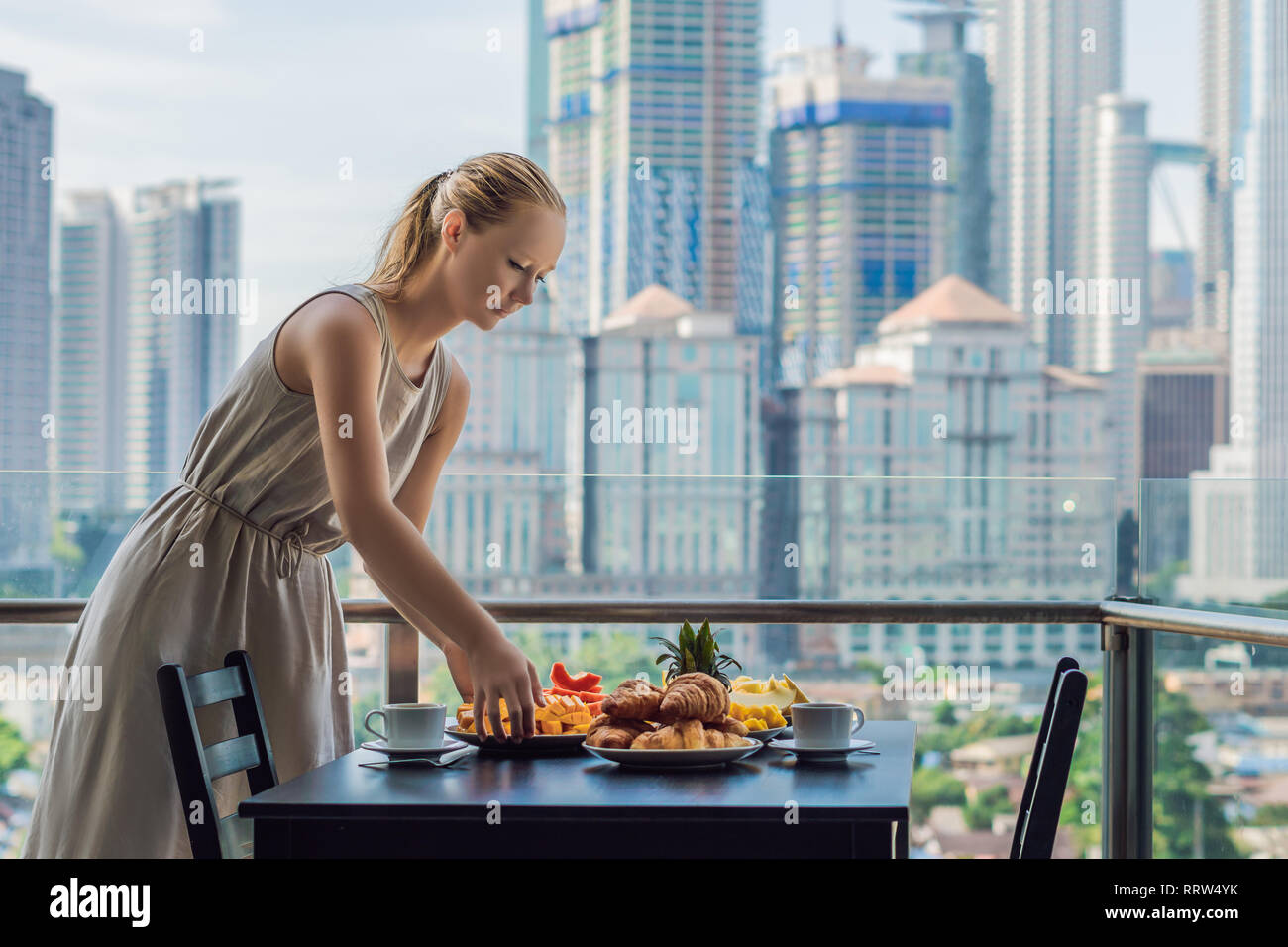 Young woman is laying on a table. Breakfast table with coffee fruit and ...