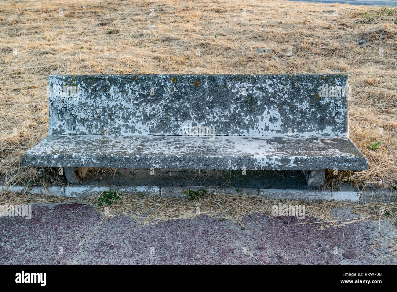 Old destroyed stone bench in the background mown dried grass Stock ...