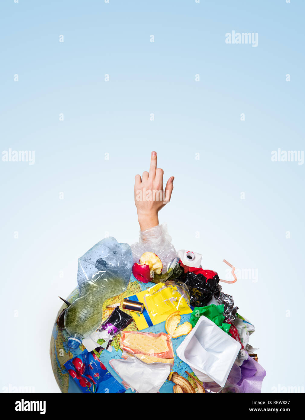 An earth globe covered with trash and male hand showing middle finger ...