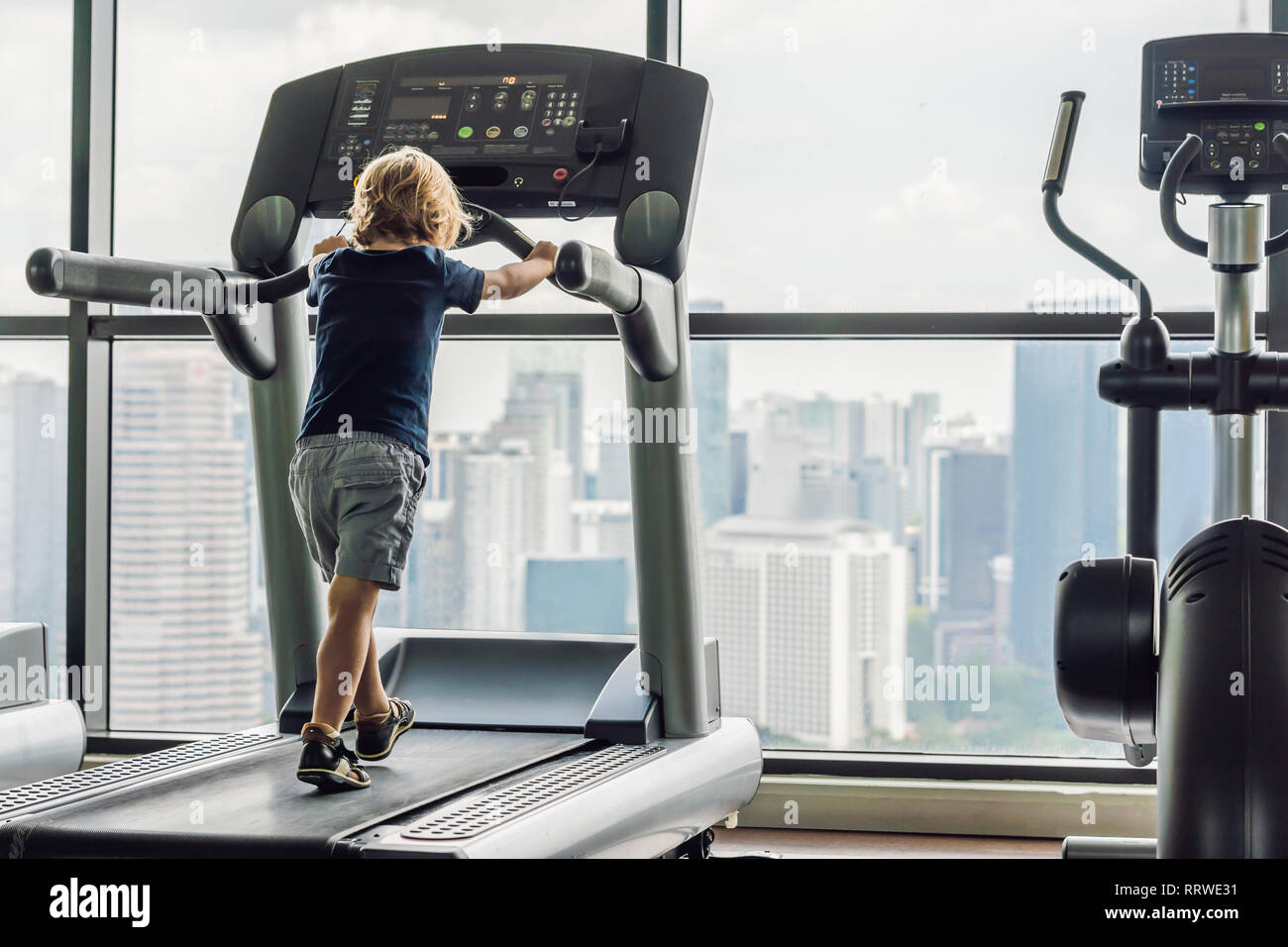 A little boy is running on the treadmill. Children's sport concept ...