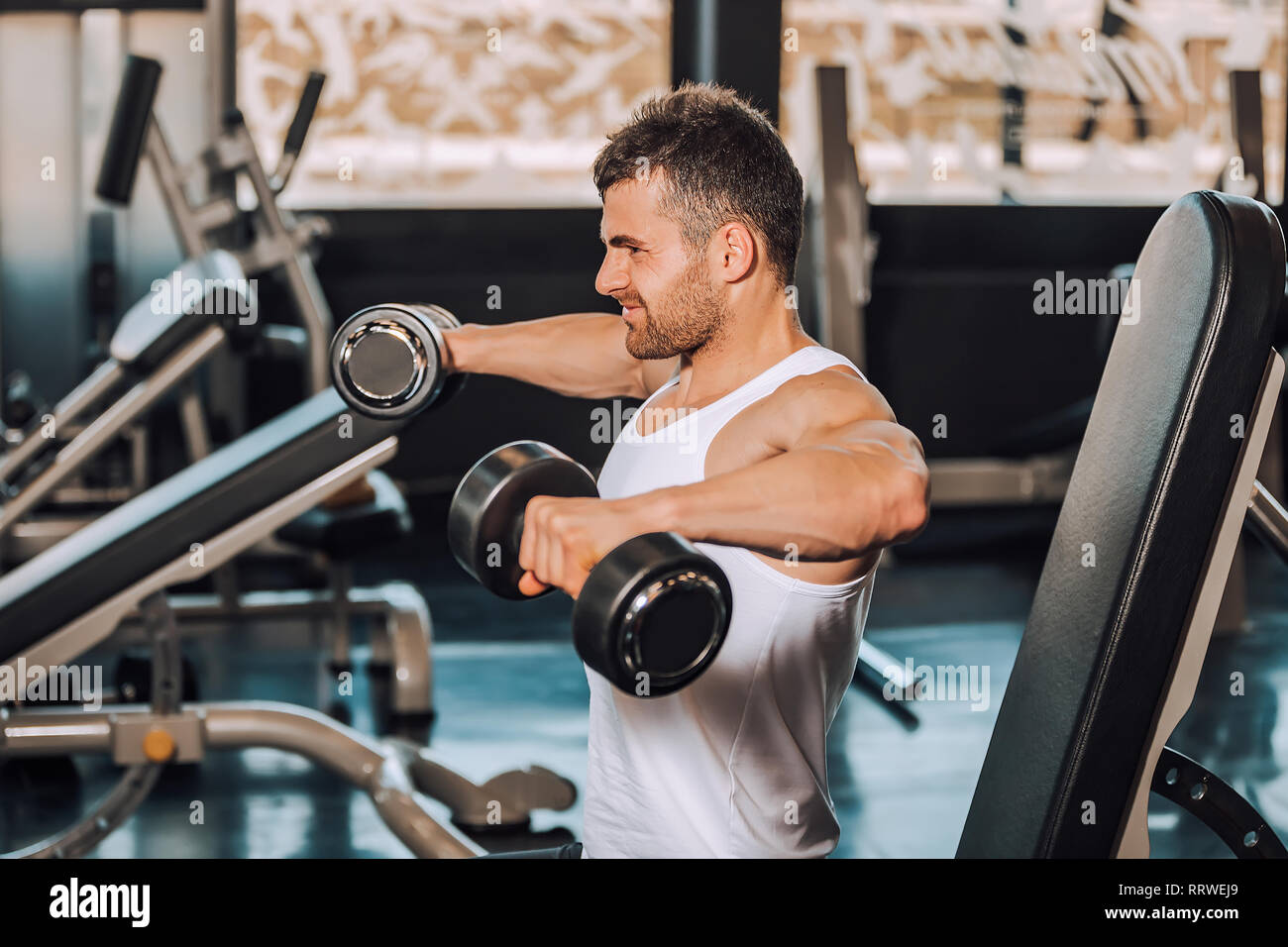 Strong man lifting dumbbells gym hi-res stock photography and images ...