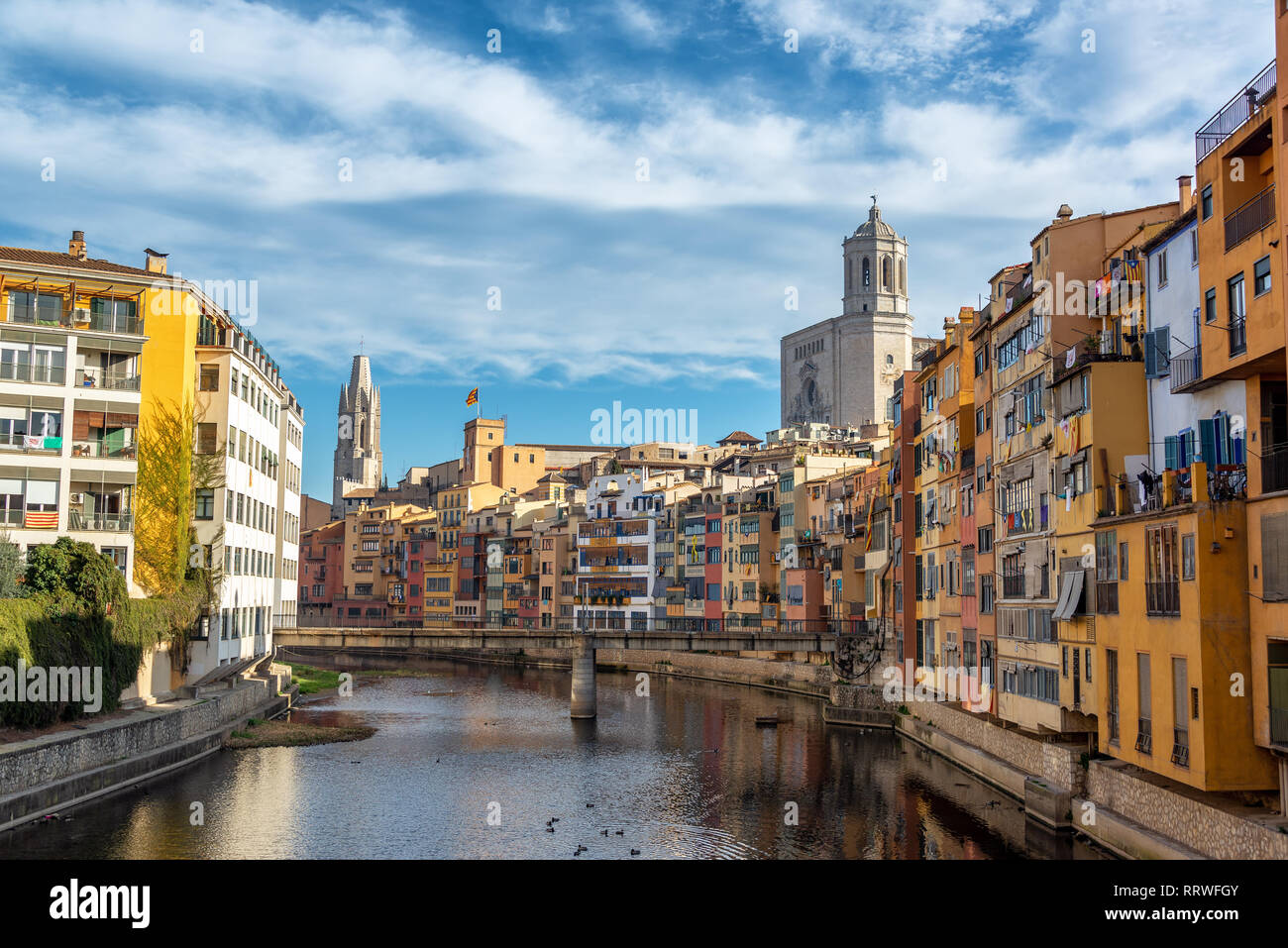 Colorful buildings on the Onyar River in Girona, Spain with the Church ...