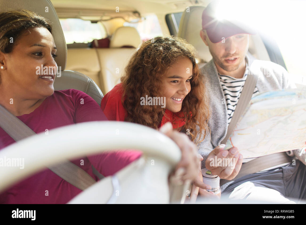 Family with map riding in car on road trip Stock Photo - Alamy