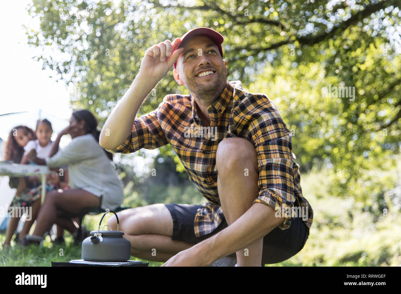 Happy man heating teapot on camping stove Stock Photo - Alamy