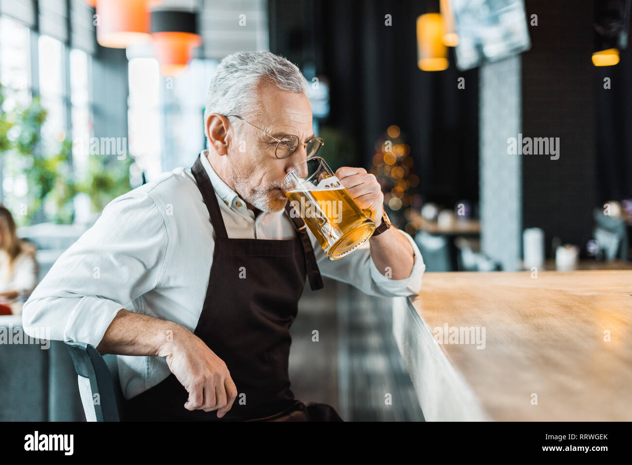 male worker in apron holding drinking beer in pub Stock Photo - Alamy