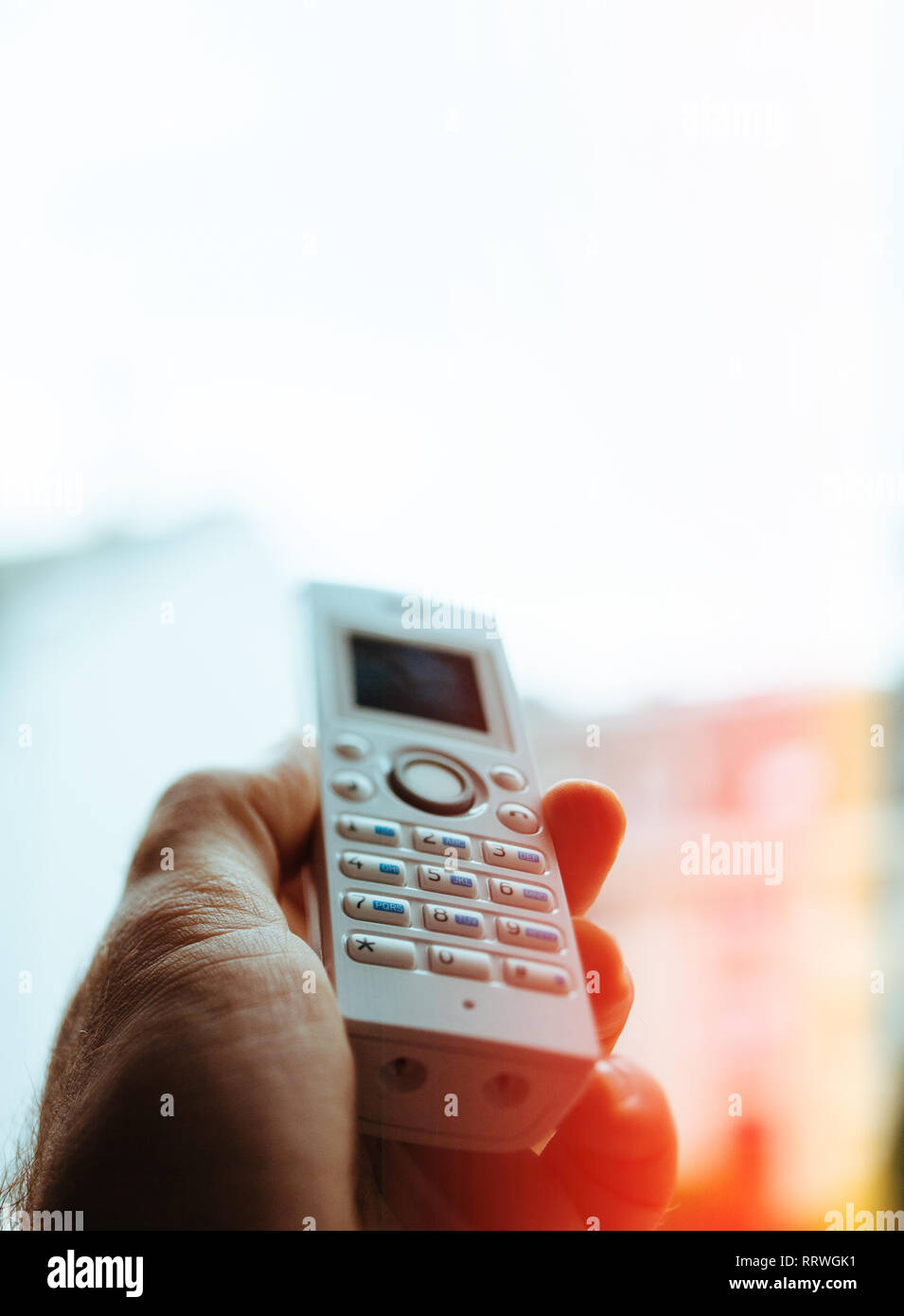 man hand holding outdoor home office white cordless dect phone dialing ...