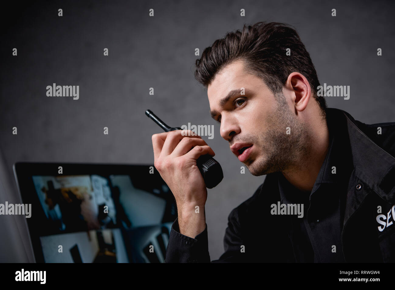 guard in uniform talking on walkie-talkie at workplace Stock Photo - Alamy