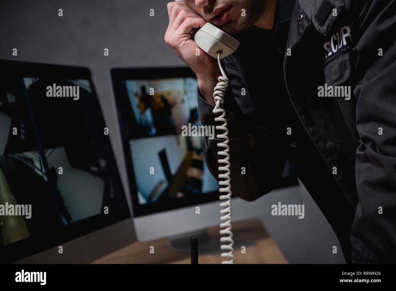 partial view of guard talking on telephone at workspace Stock Photo - Alamy