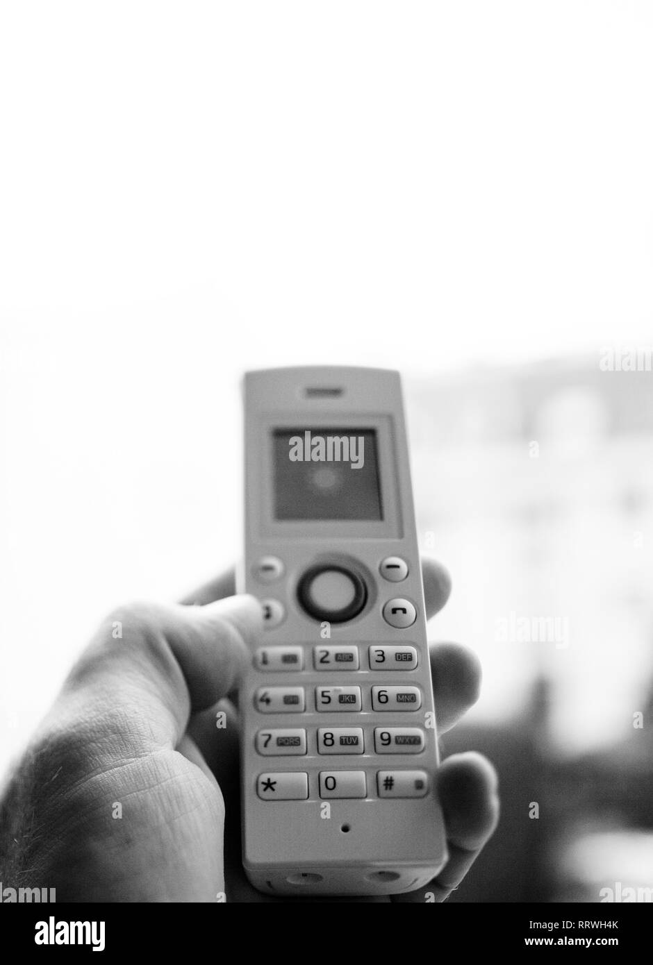 man hand holding outdoor home office white cordless phone dialing a ...