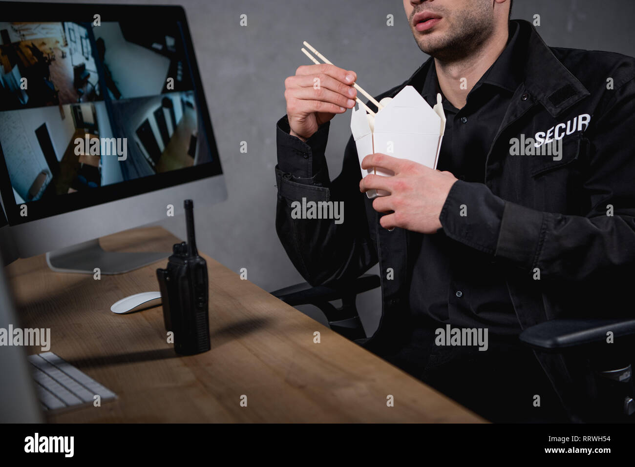 cropped view of guard in uniform eating junk food Stock Photo - Alamy